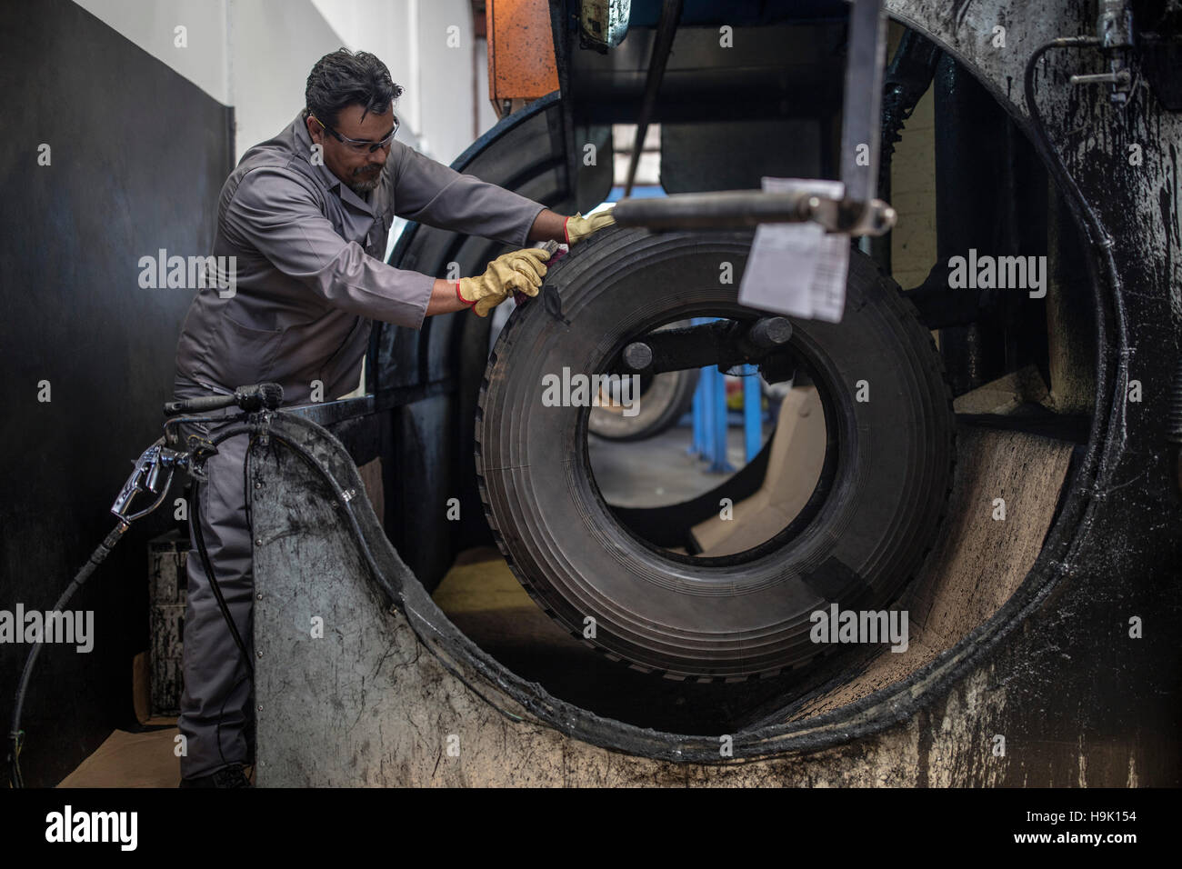 Repairman working on tire in factory Stock Photo - Alamy