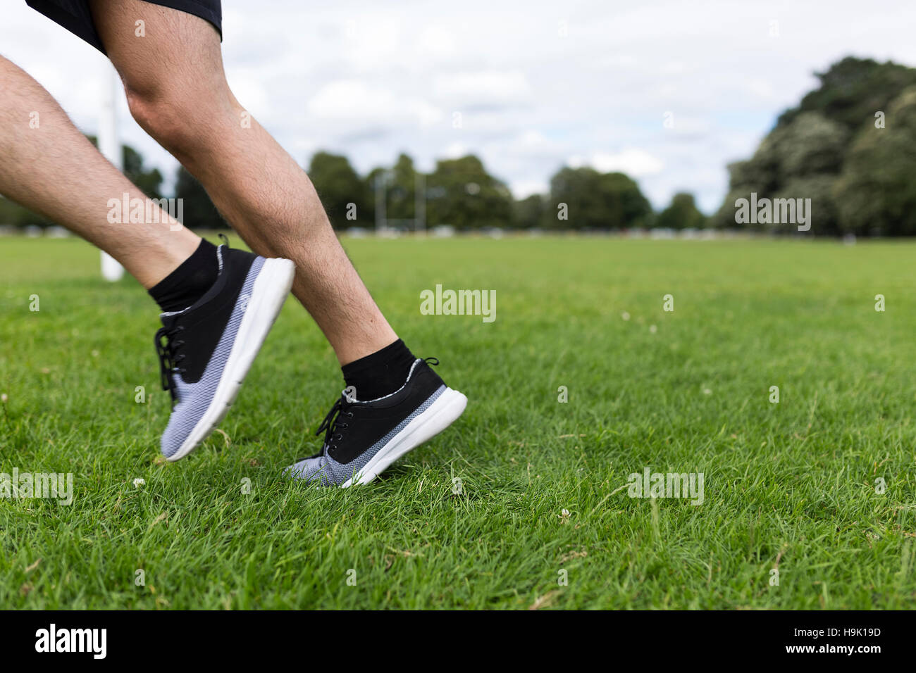 Legs of athlete running on grass Stock Photo - Alamy