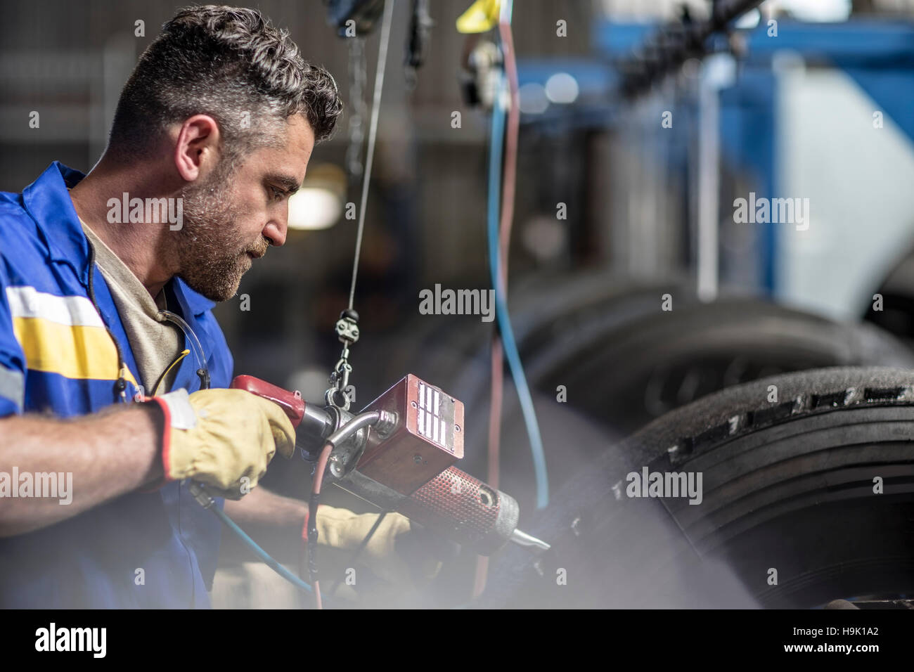 Repairman working on tire in factory Stock Photo - Alamy
