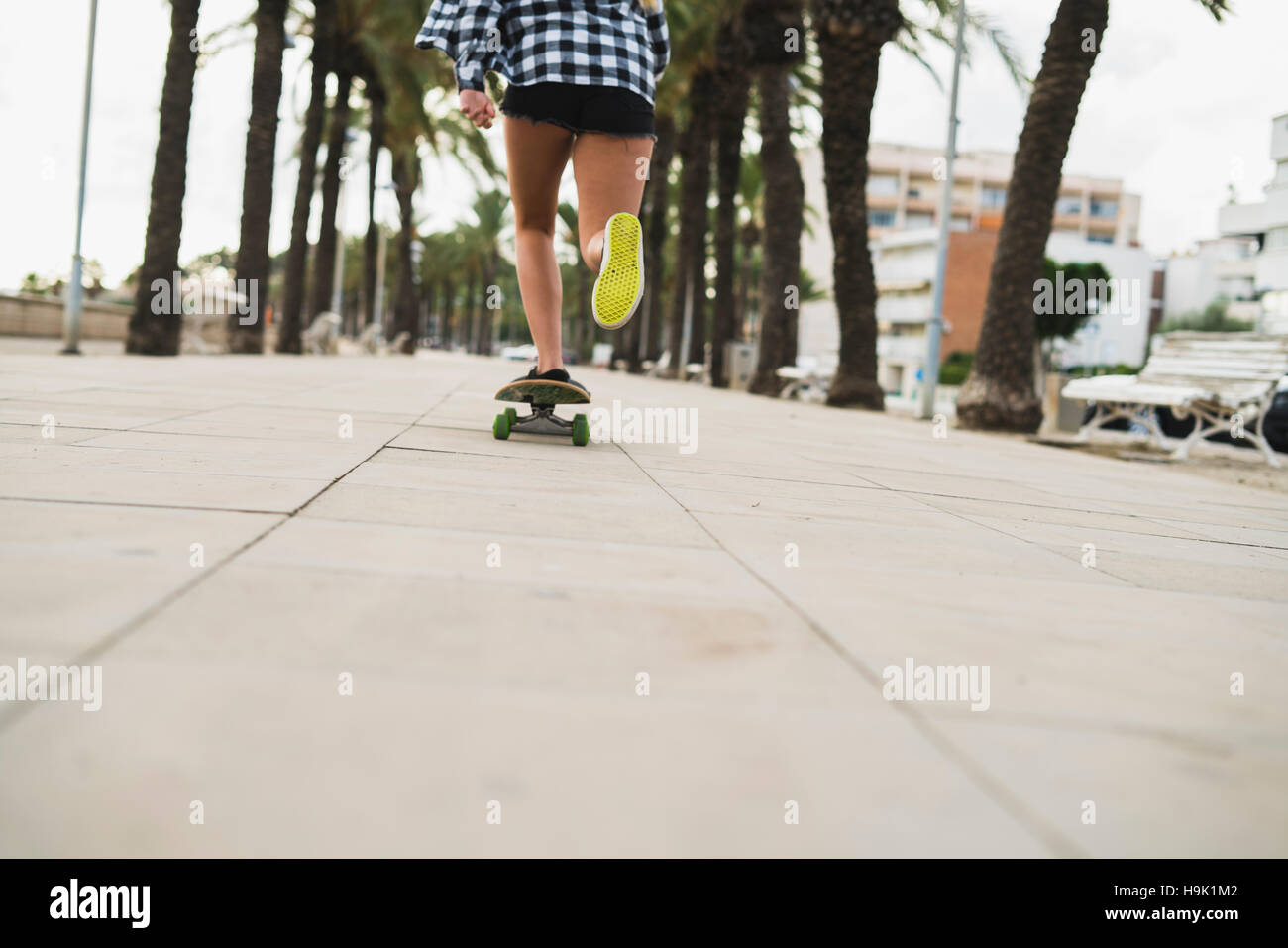 Back view of young woman skateboarding Stock Photo - Alamy