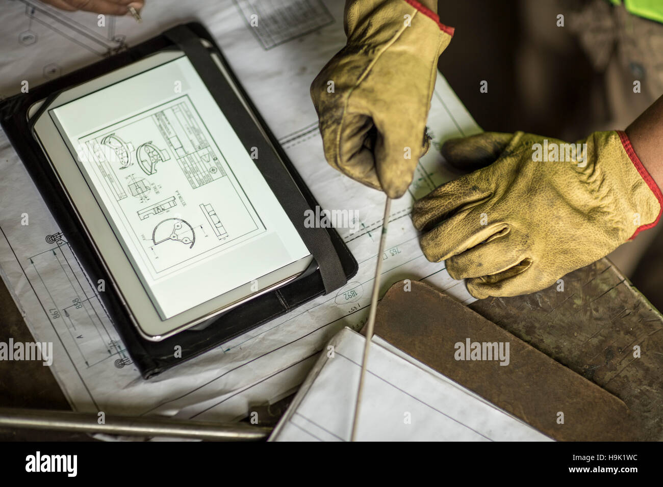 Man in construction company working with blueprint on digital tablet ...