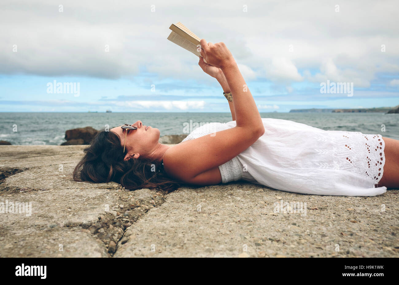 Woman reading on pier hi-res stock photography and images - Alamy