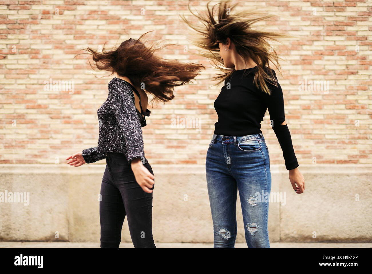 Two women tossing hair hi-res stock photography and images - Alamy