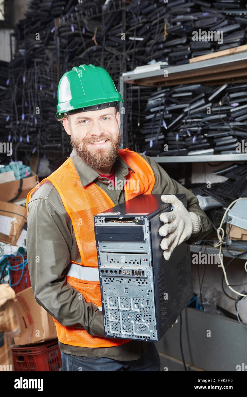 Worker in computer recycling plant holding pc casing Stock Photo - Alamy