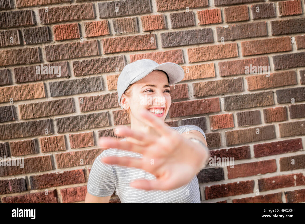 Smiling woman raising her hand Stock Photo - Alamy