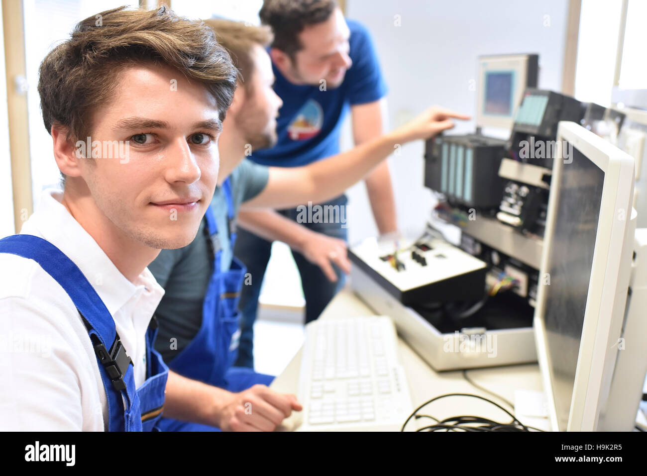 Portrait of smiling student with technical instructor in background ...