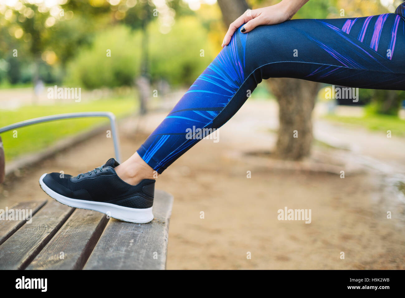 Leg of sportive woman on park bench Stock Photo - Alamy