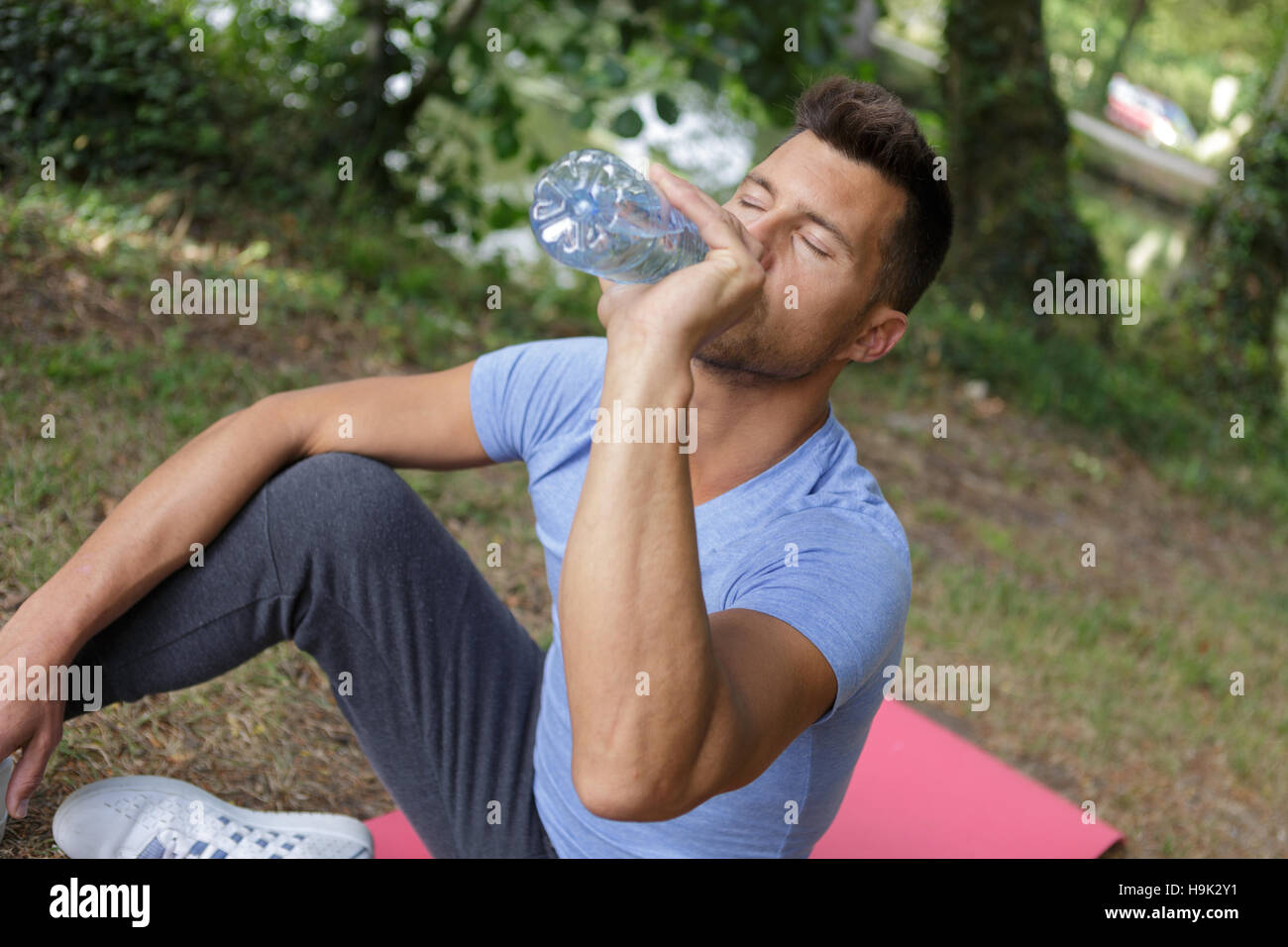 man drinking water while resting during outdoor training workout Stock ...