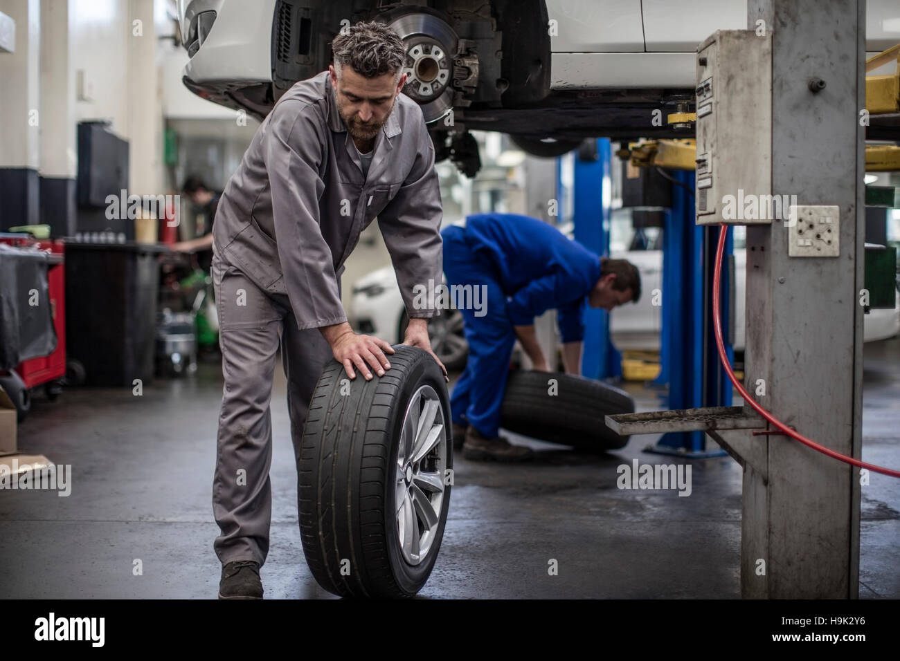 Car mechanics in a workshop changing tires Stock Photo - Alamy