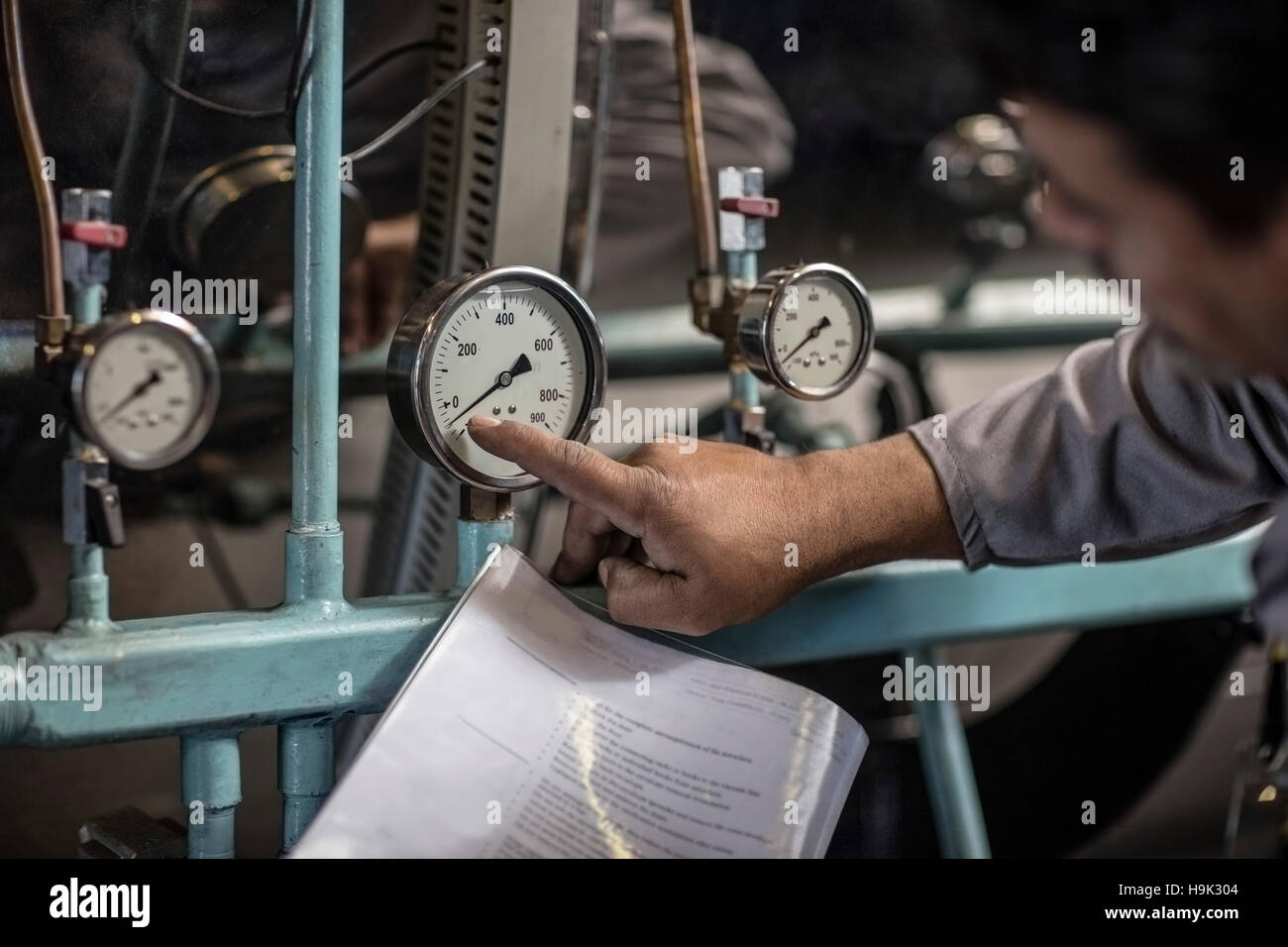 Man checking pressure on machine Stock Photo - Alamy
