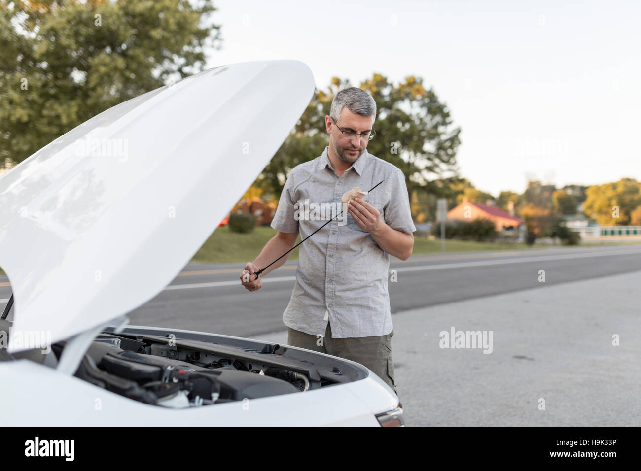 Man checking oil level at the road side Stock Photo - Alamy