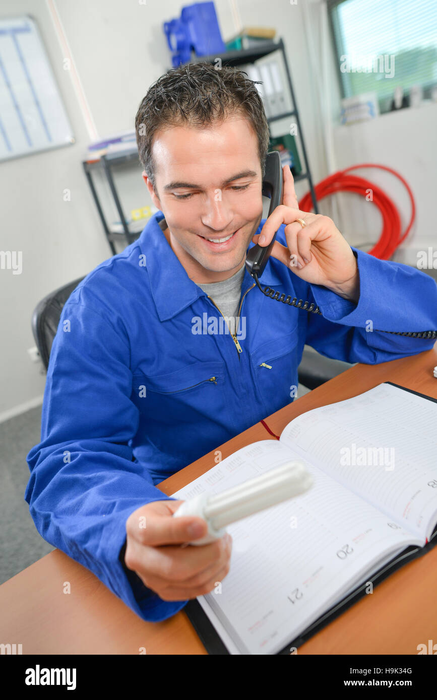 Electrician writing in his agenda Stock Photo - Alamy