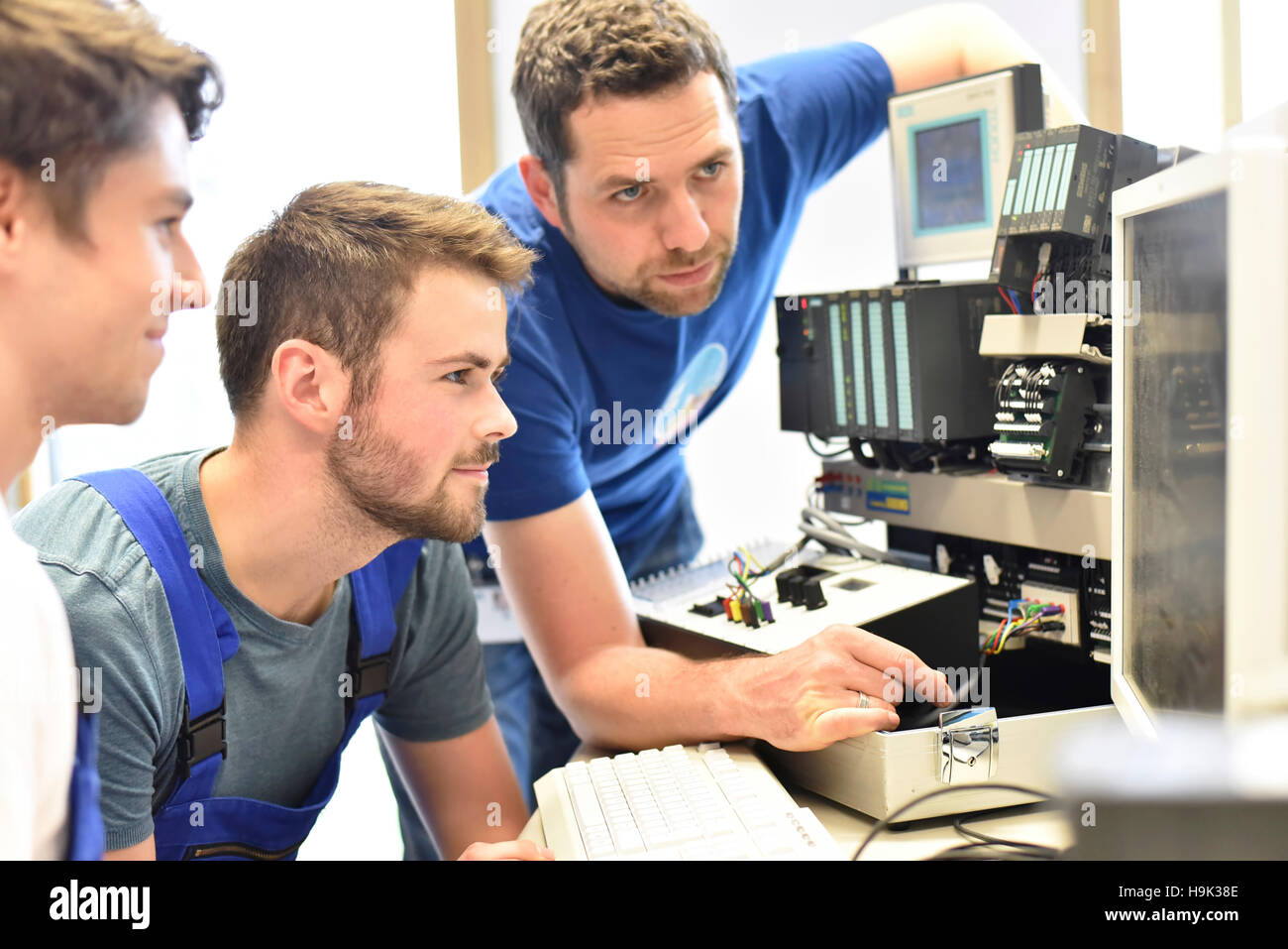 Technical instructor teaching students at computer screen Stock Photo ...