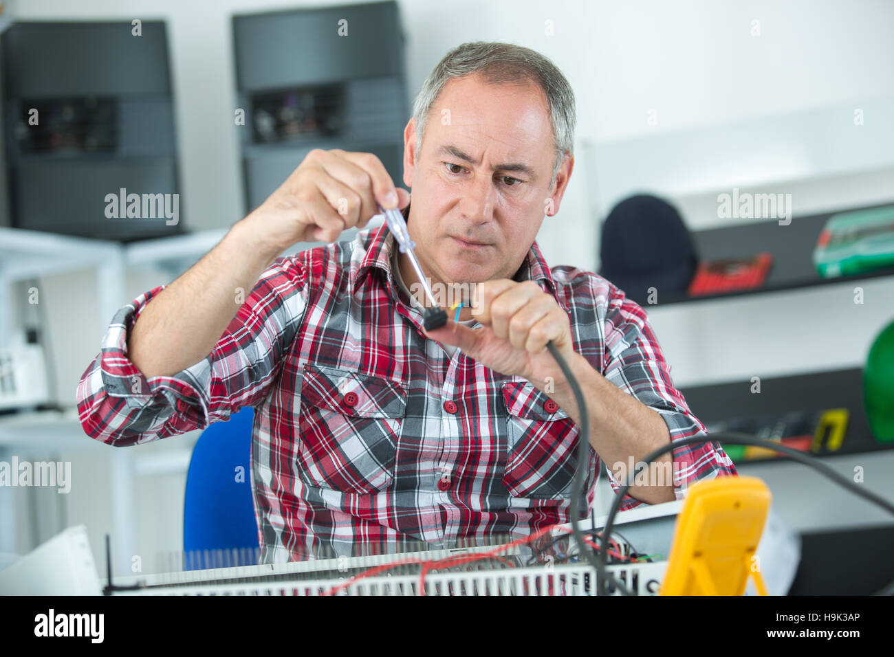 repairer hands with screwdriver disassembling damaged unit for repair ...