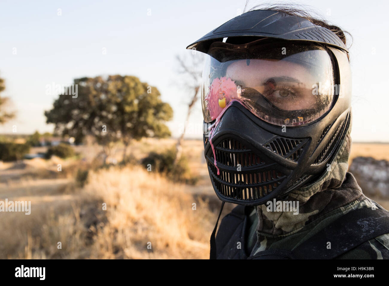Female paintball player with paintball mask stained with paint Stock ...
