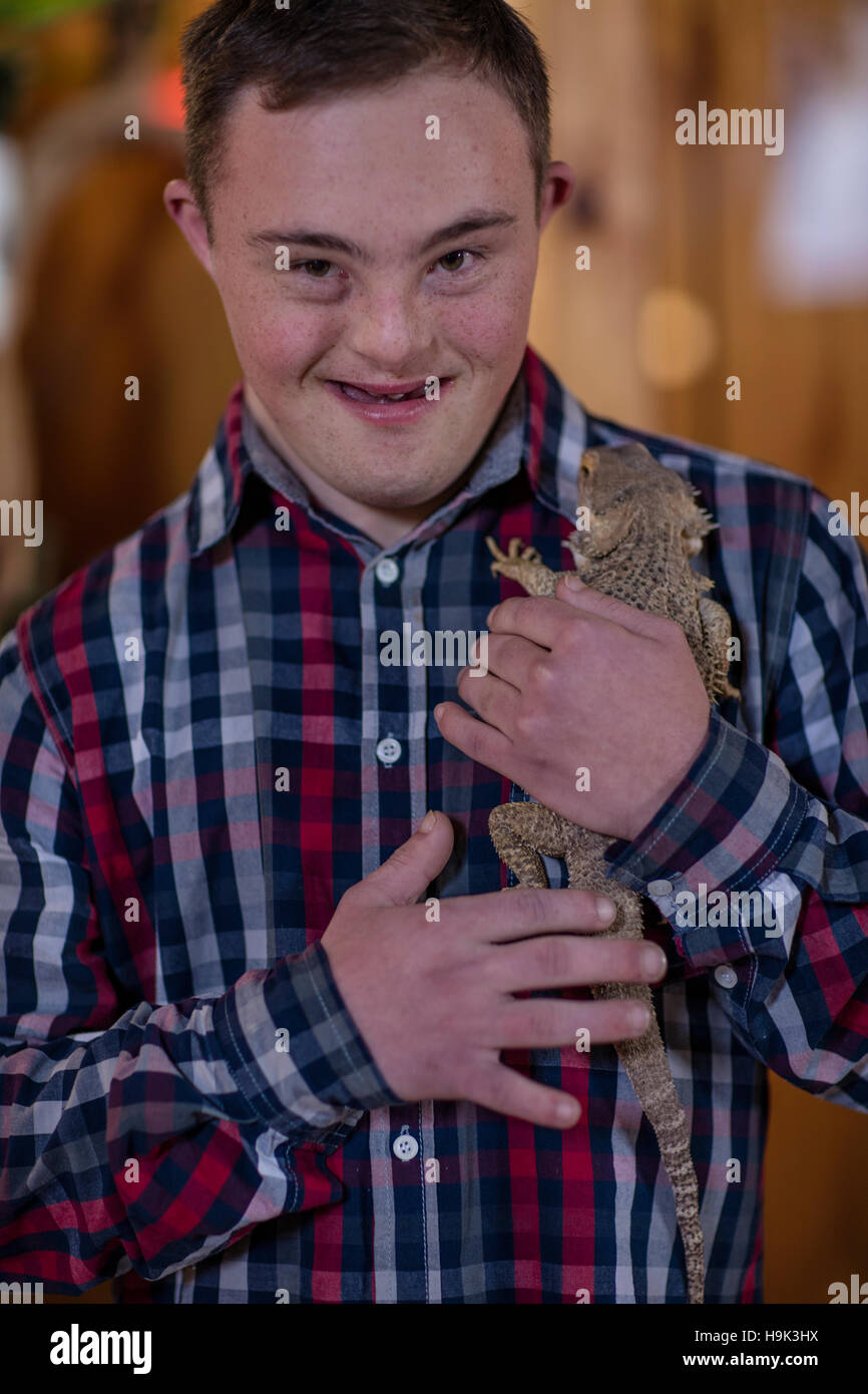 Young man with down syndrome holding a bearded dragon Stock Photo - Alamy