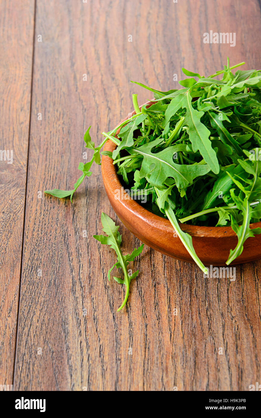 Arugula on woody background Stock Photo - Alamy