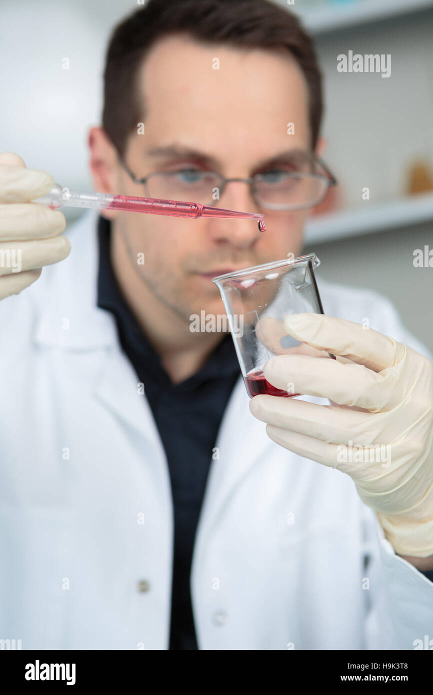 scientist in laboratory holding pipette and test tube Stock Photo - Alamy