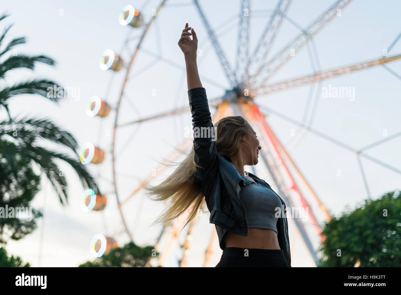 Enthusiastic young woman on a funfair with a ferris wheel Stock Photo ...