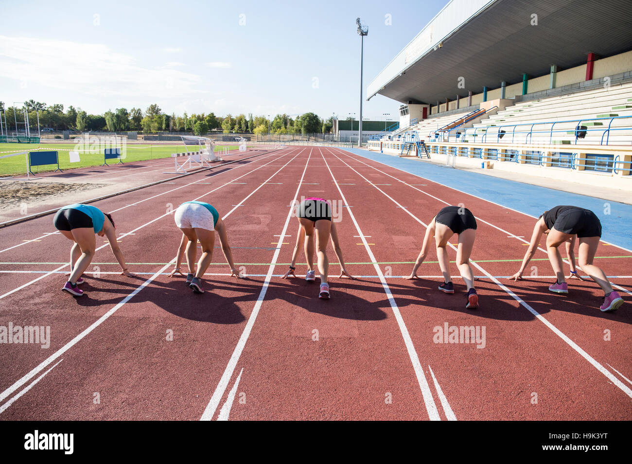 Female runners on tartan track in starting position Stock Photo - Alamy