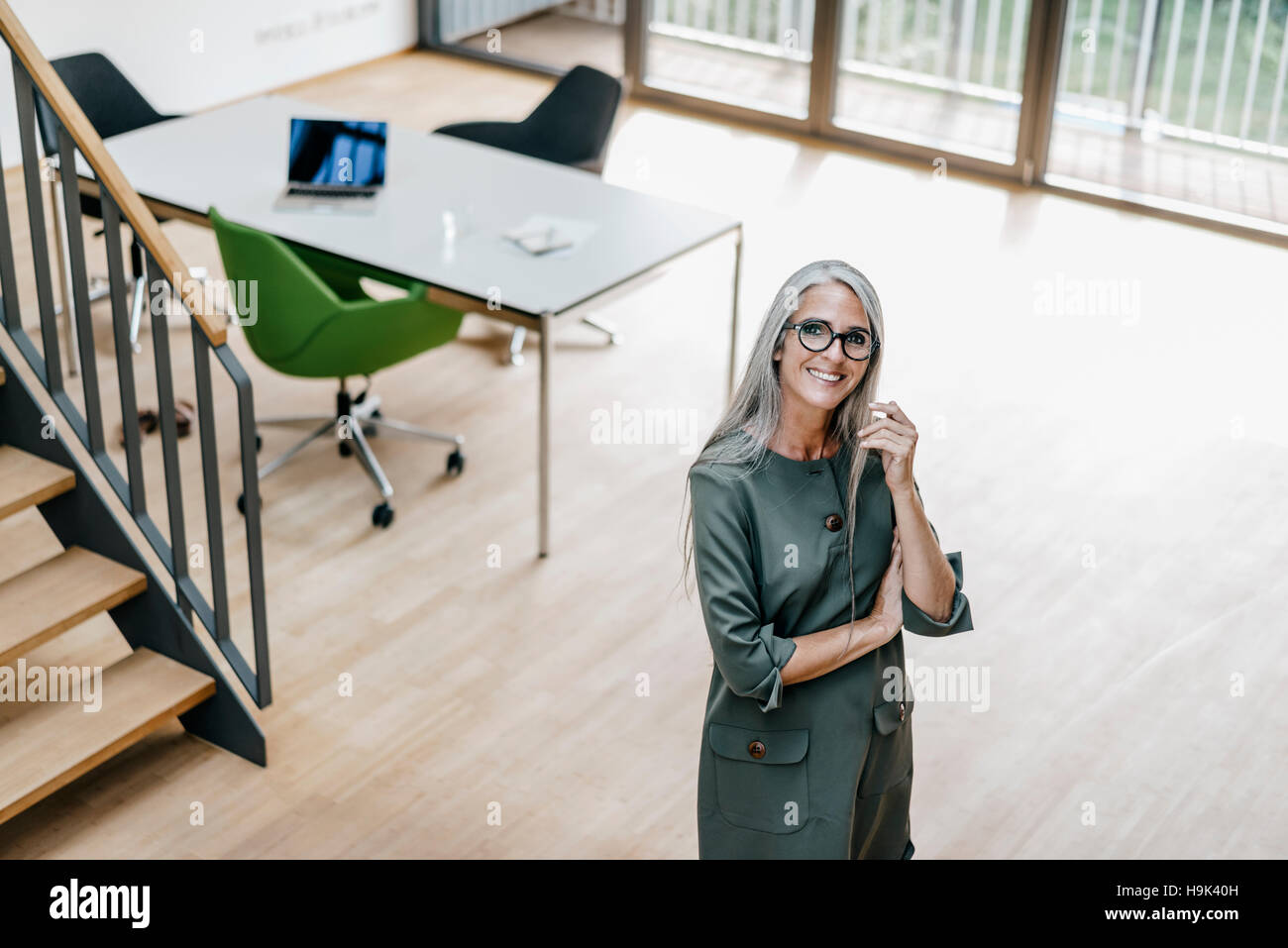 Portrait of smiling woman with long grey hair in office Stock Photo - Alamy