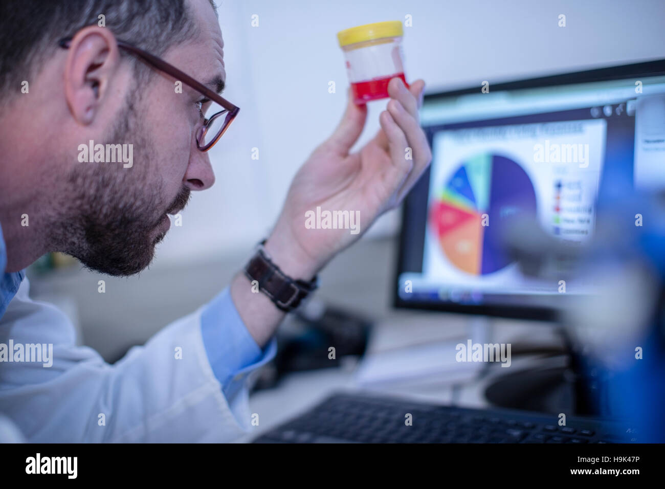 Man looking at sample in laboratory Stock Photo - Alamy