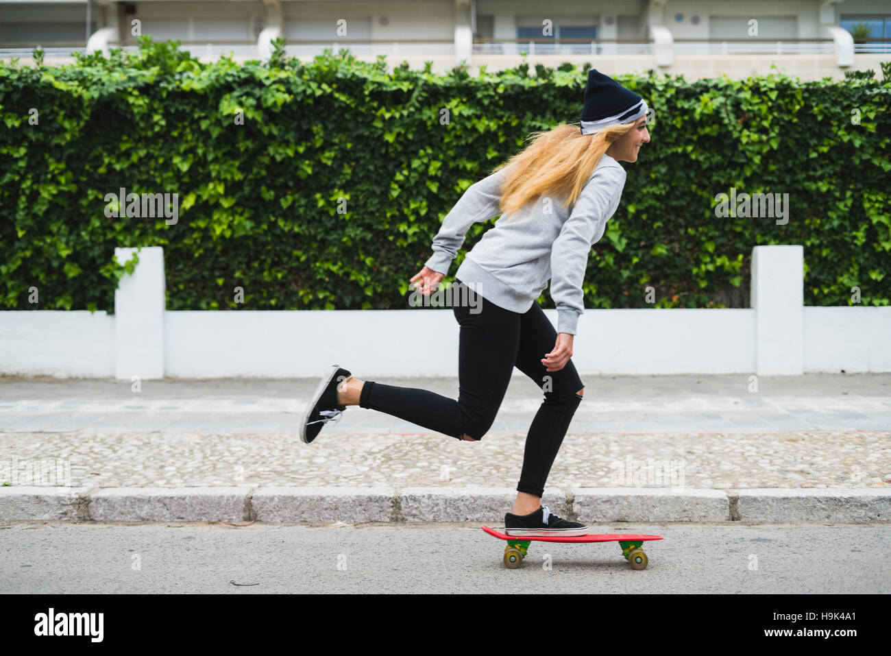 Young woman skateboarding on street Stock Photo - Alamy