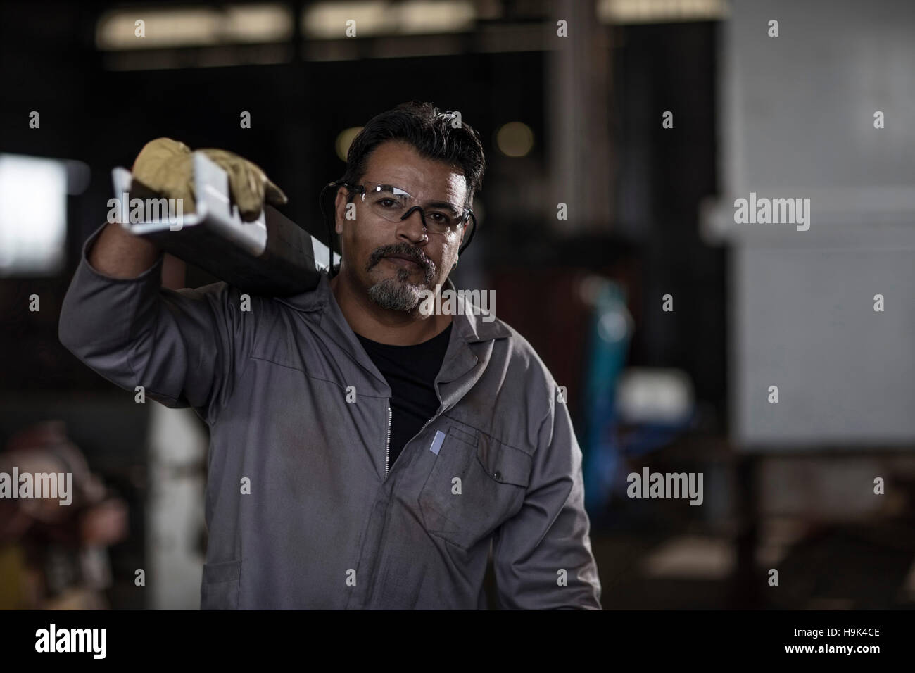 Metal worker carrying steel girder Stock Photo - Alamy