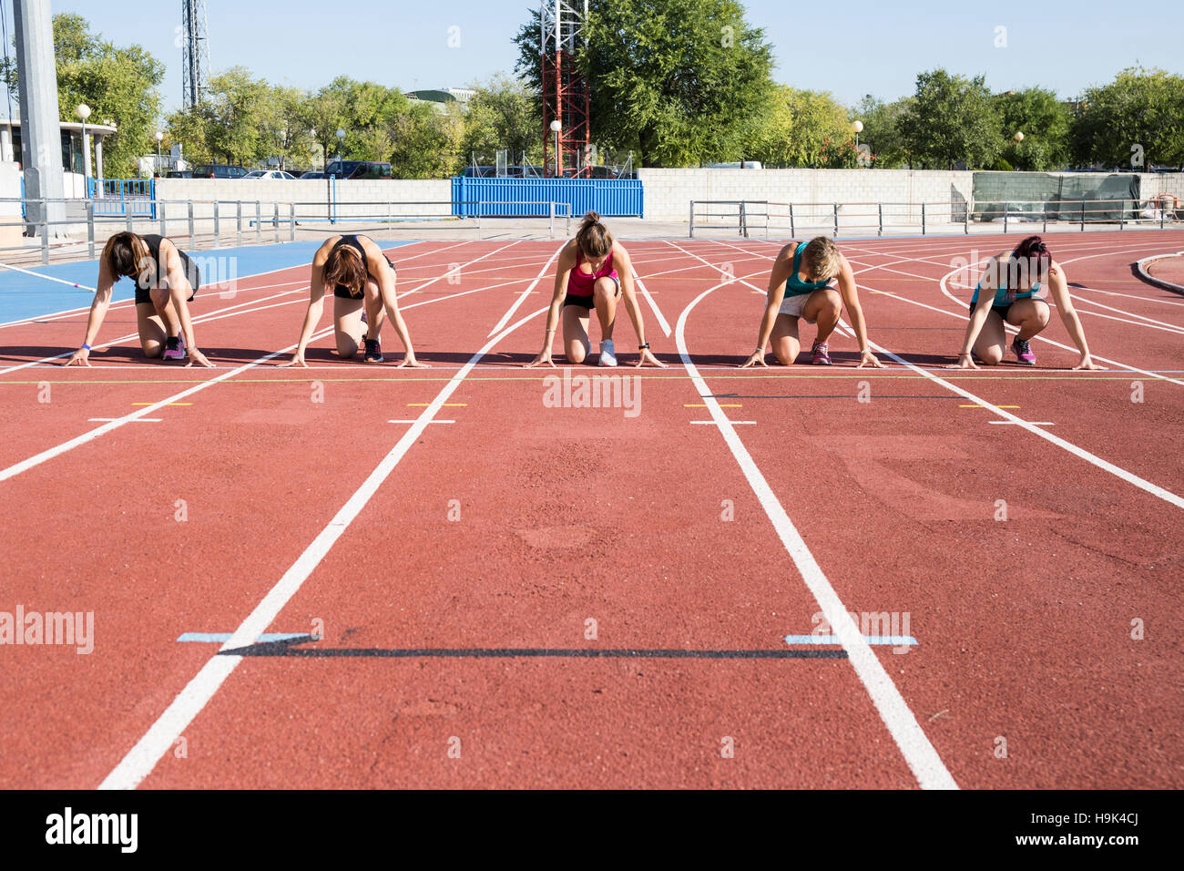 Female runners on tartan track in starting position Stock Photo - Alamy