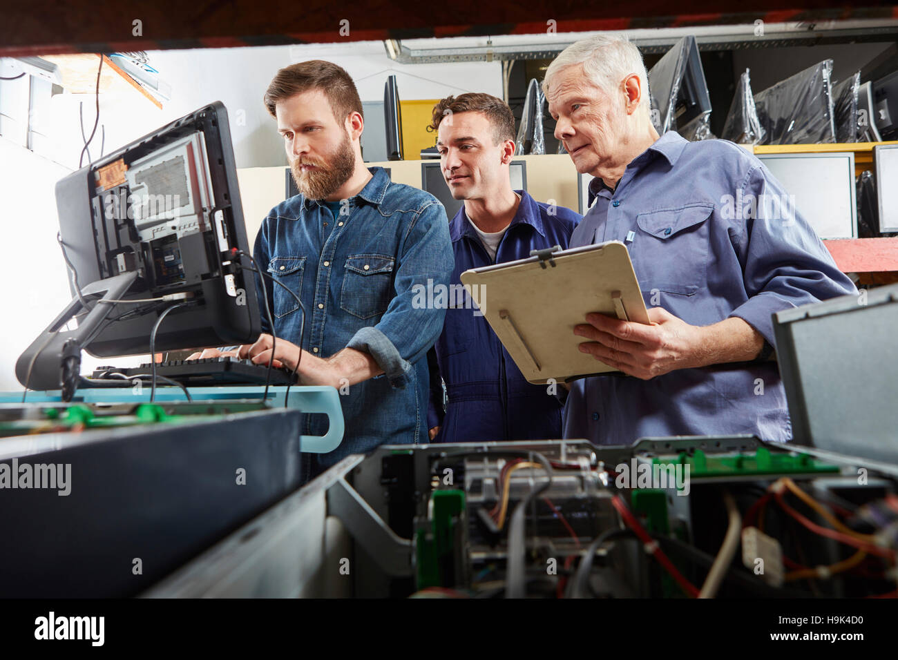 People in computer recycling plant checking desktop pc Stock Photo - Alamy
