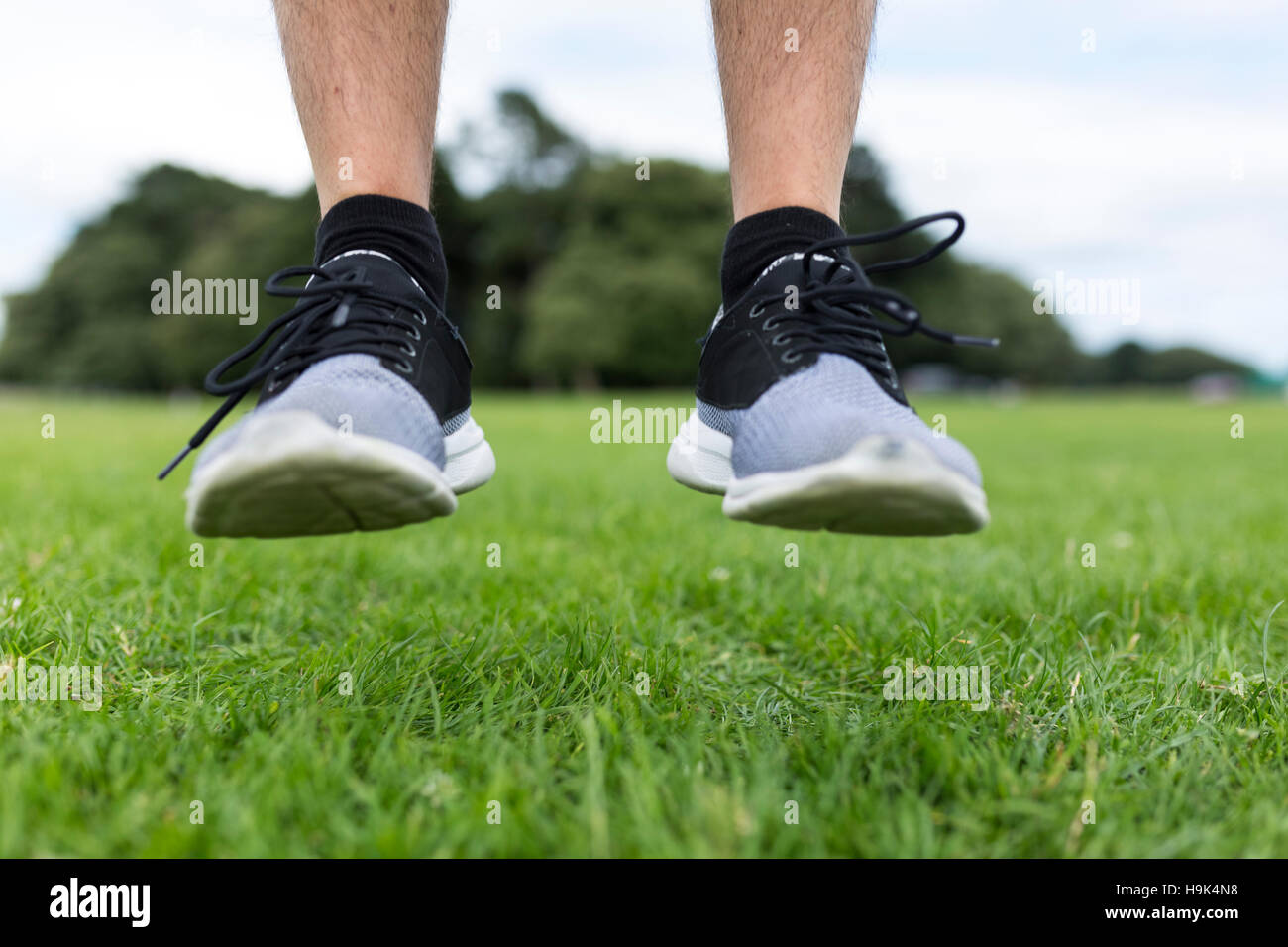 Shoes of athlete jumping on meadow Stock Photo - Alamy