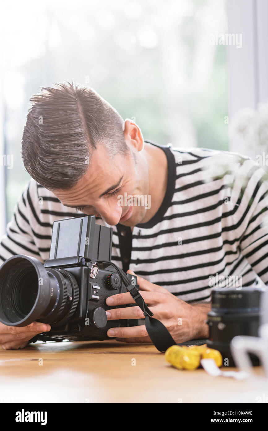 Man at home checking camera Stock Photo - Alamy