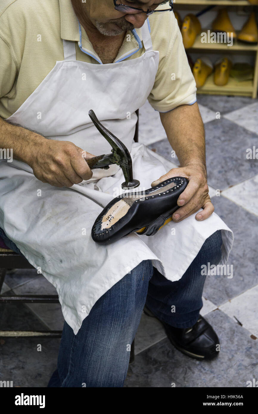 Shoemaker working with hammer on shoe in his workshop Stock Photo - Alamy