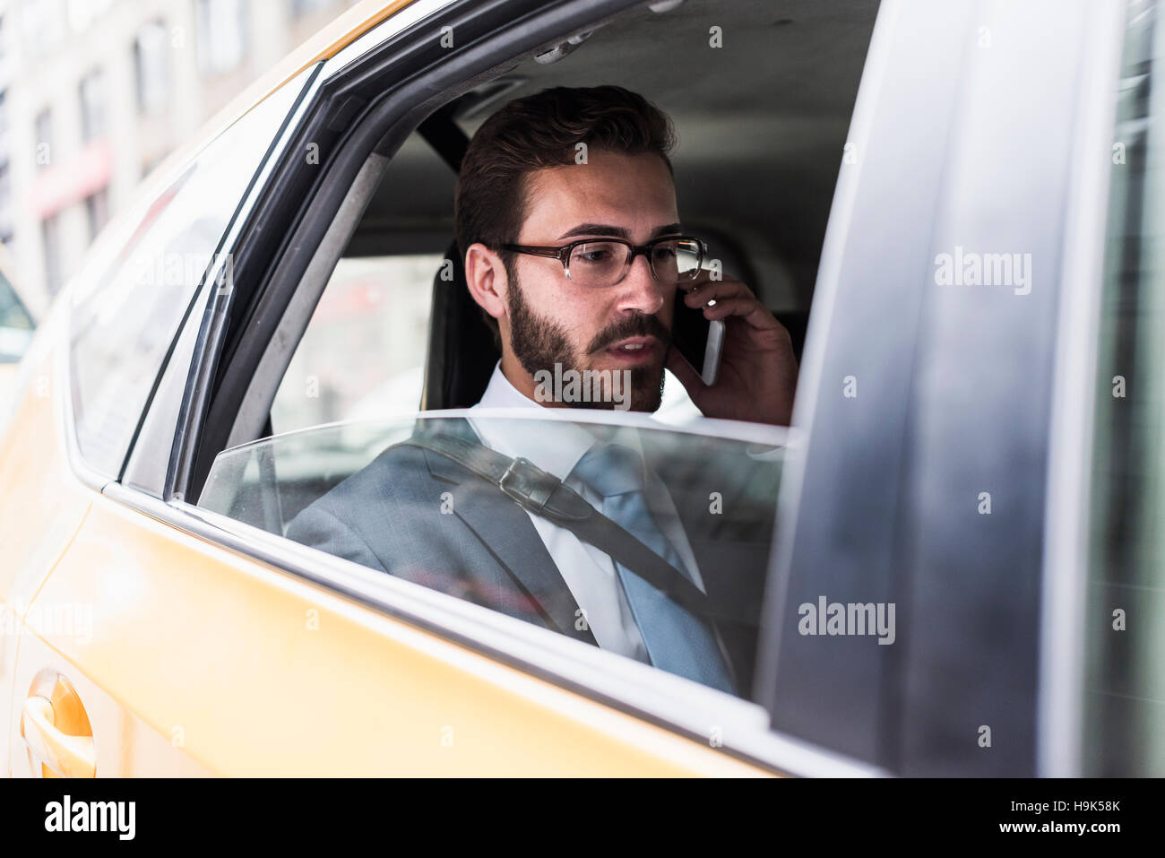 Businessman on cell phone in a taxi Stock Photo - Alamy