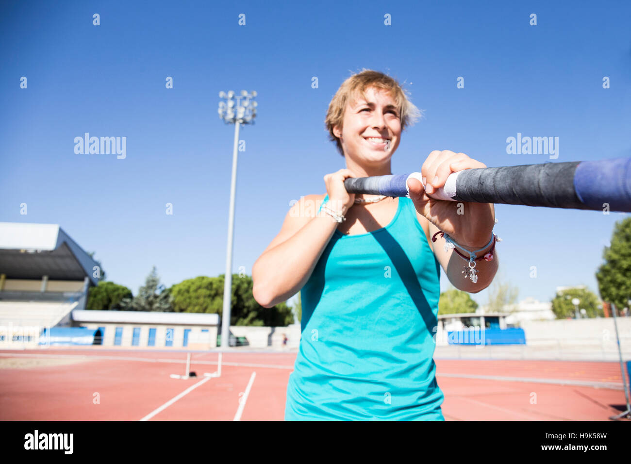Smiling female pole vaulter preparing Stock Photo - Alamy