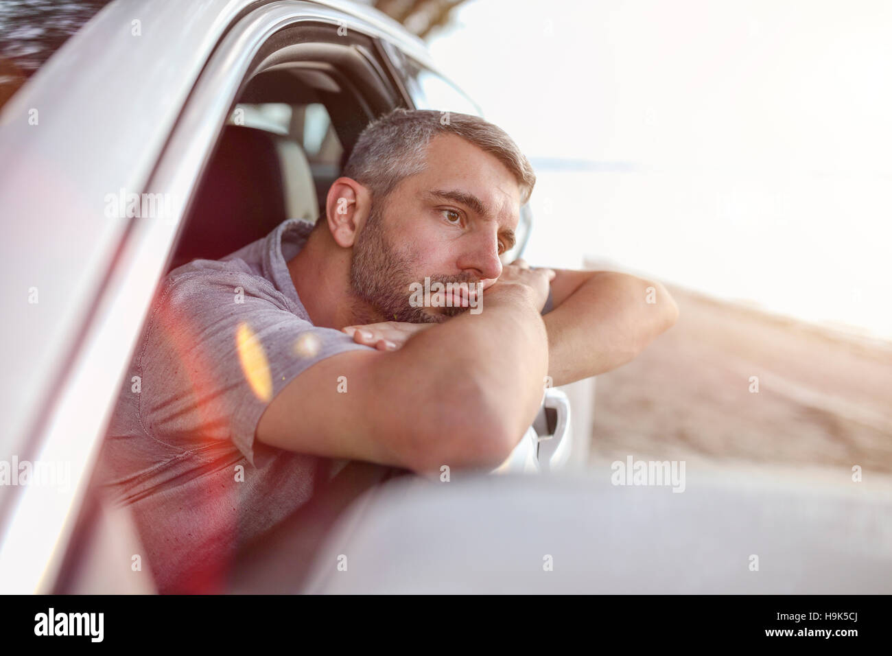Man sitting in car, taking a break Stock Photo - Alamy
