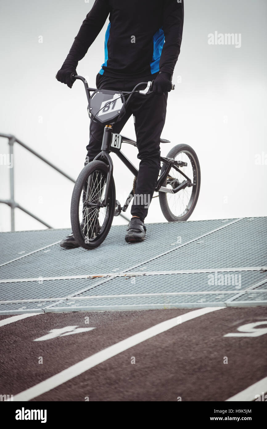Cyclist standing with BMX bike at starting ramp Stock Photo - Alamy