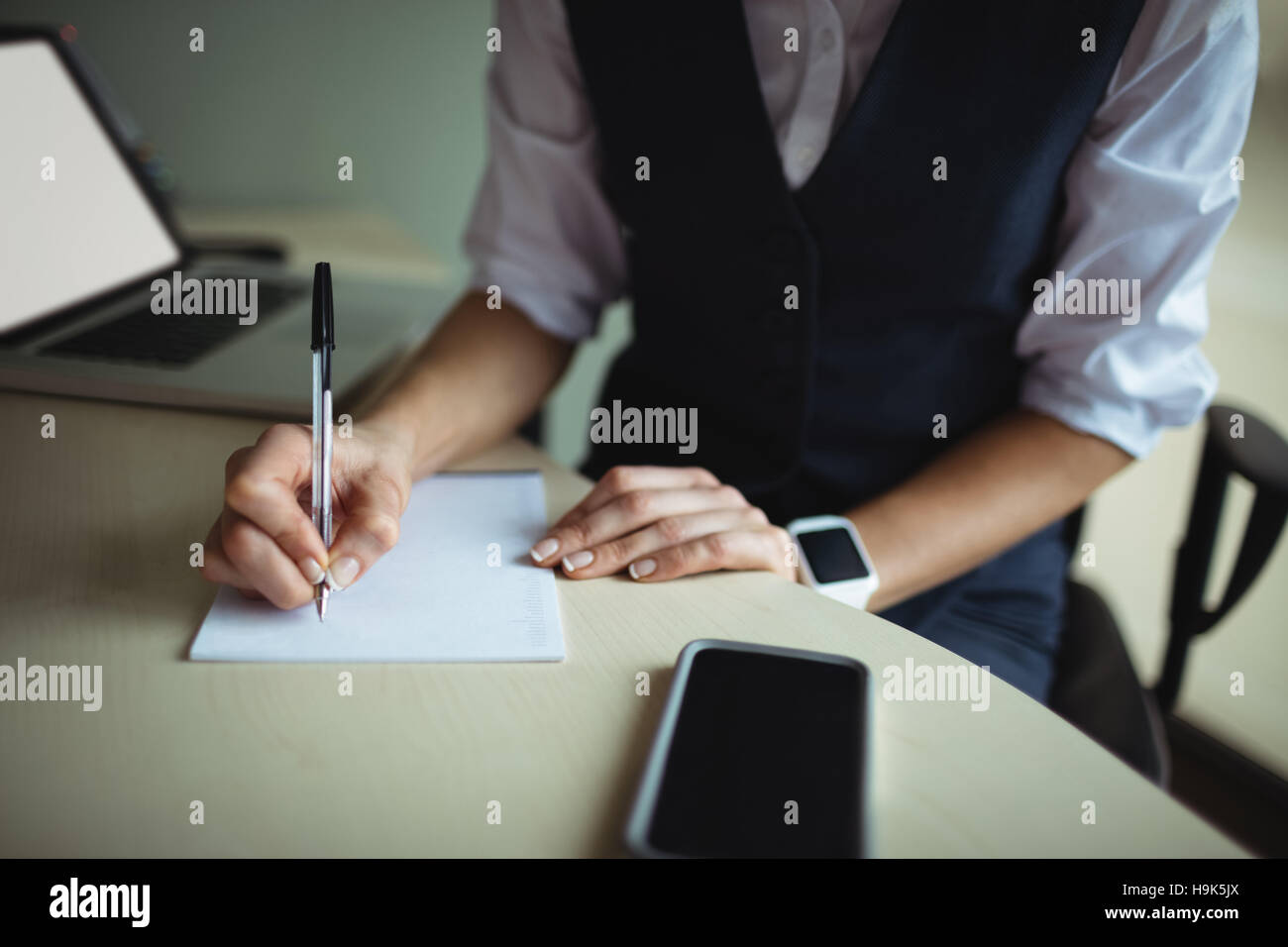 Businesswoman writing on notepad Stock Photo - Alamy