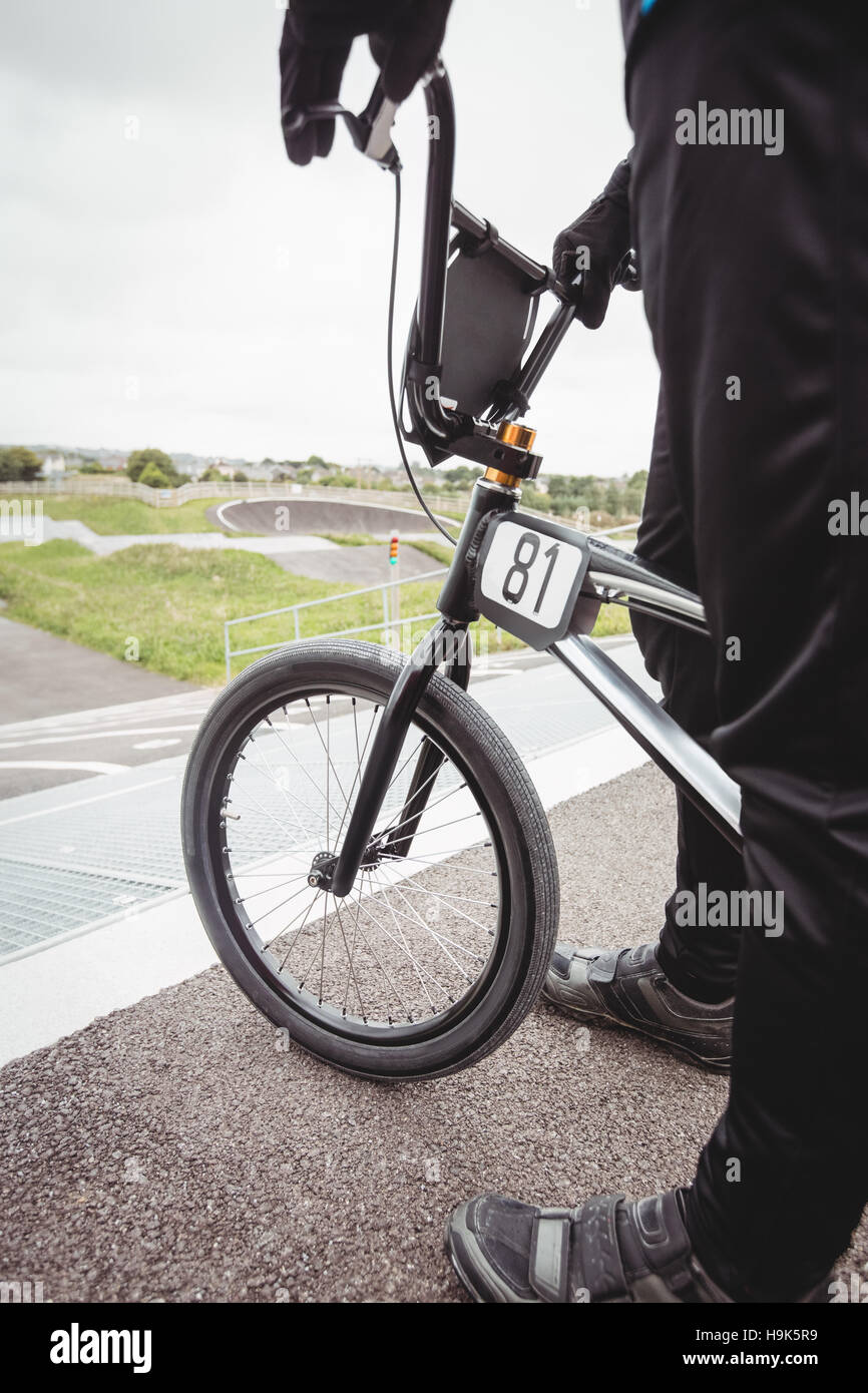Cyclist standing with BMX bike at starting ramp Stock Photo - Alamy