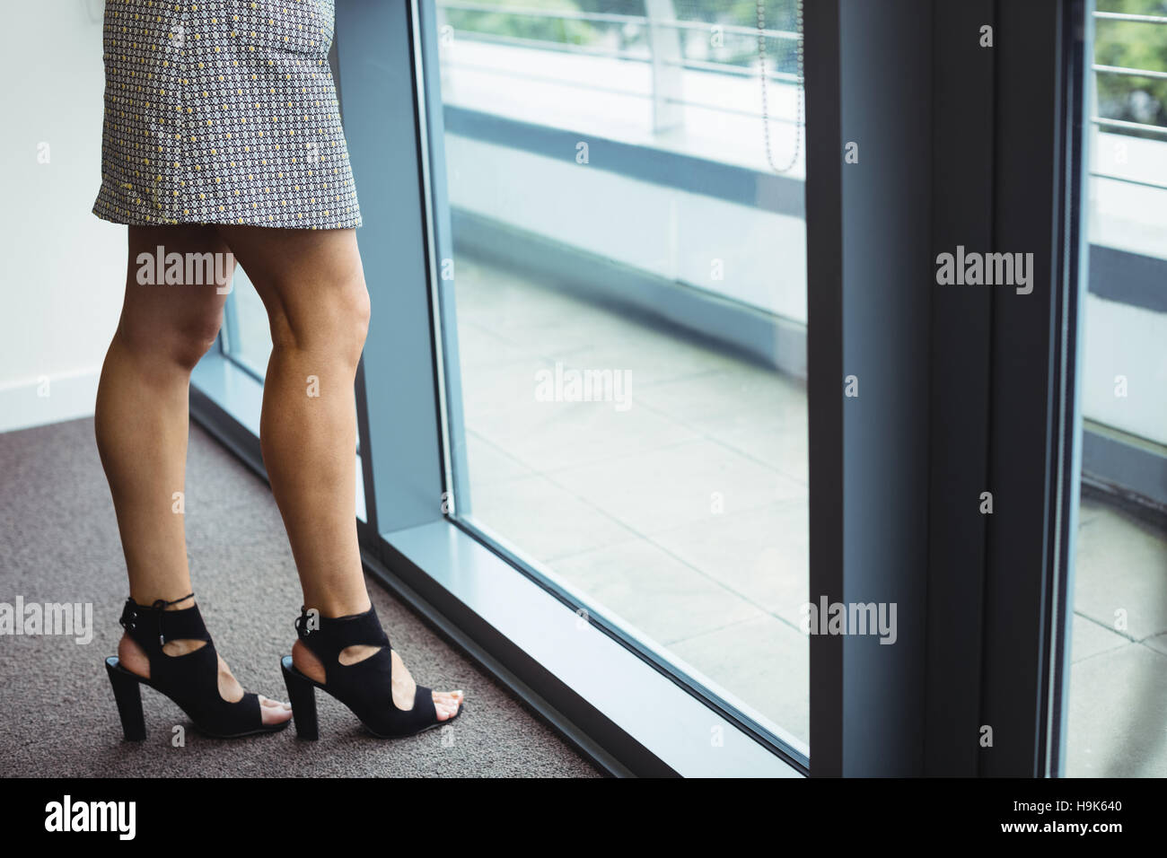 Businesswoman standing near window Stock Photo - Alamy