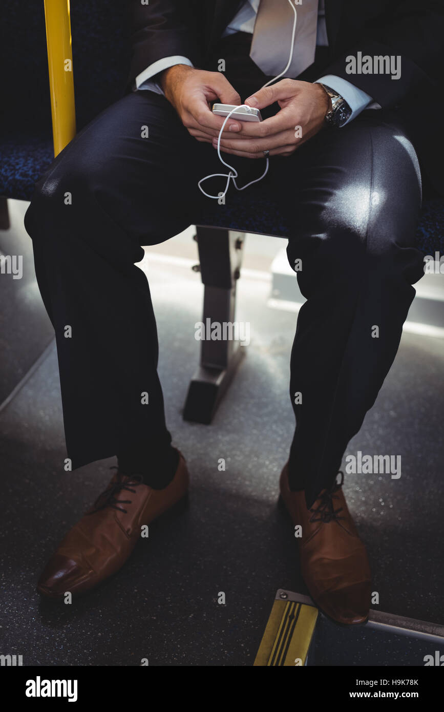 Businessman using mobile phone while travelling Stock Photo - Alamy
