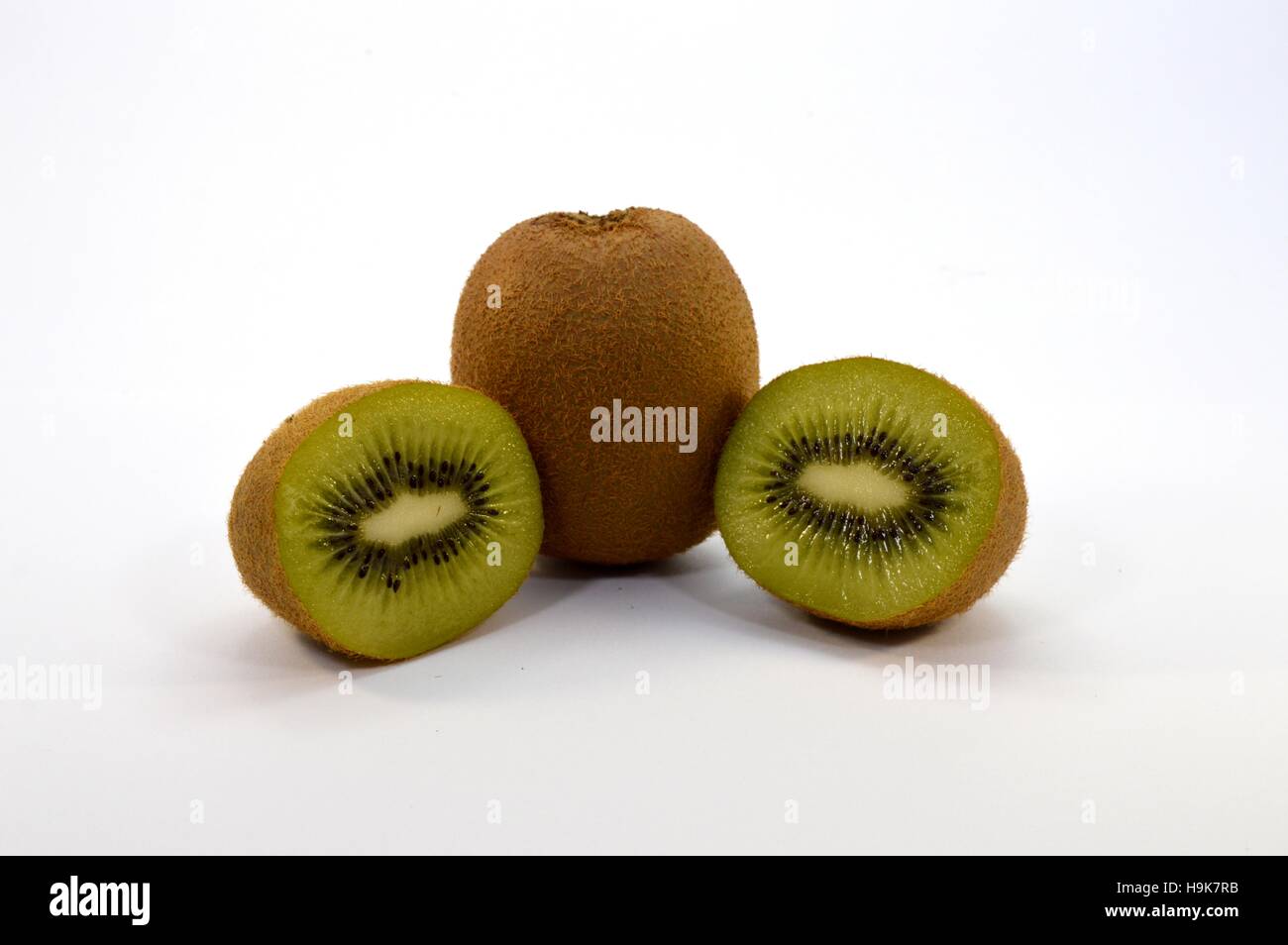 Kiwi whole and cut in half on a white background Stock Photo - Alamy