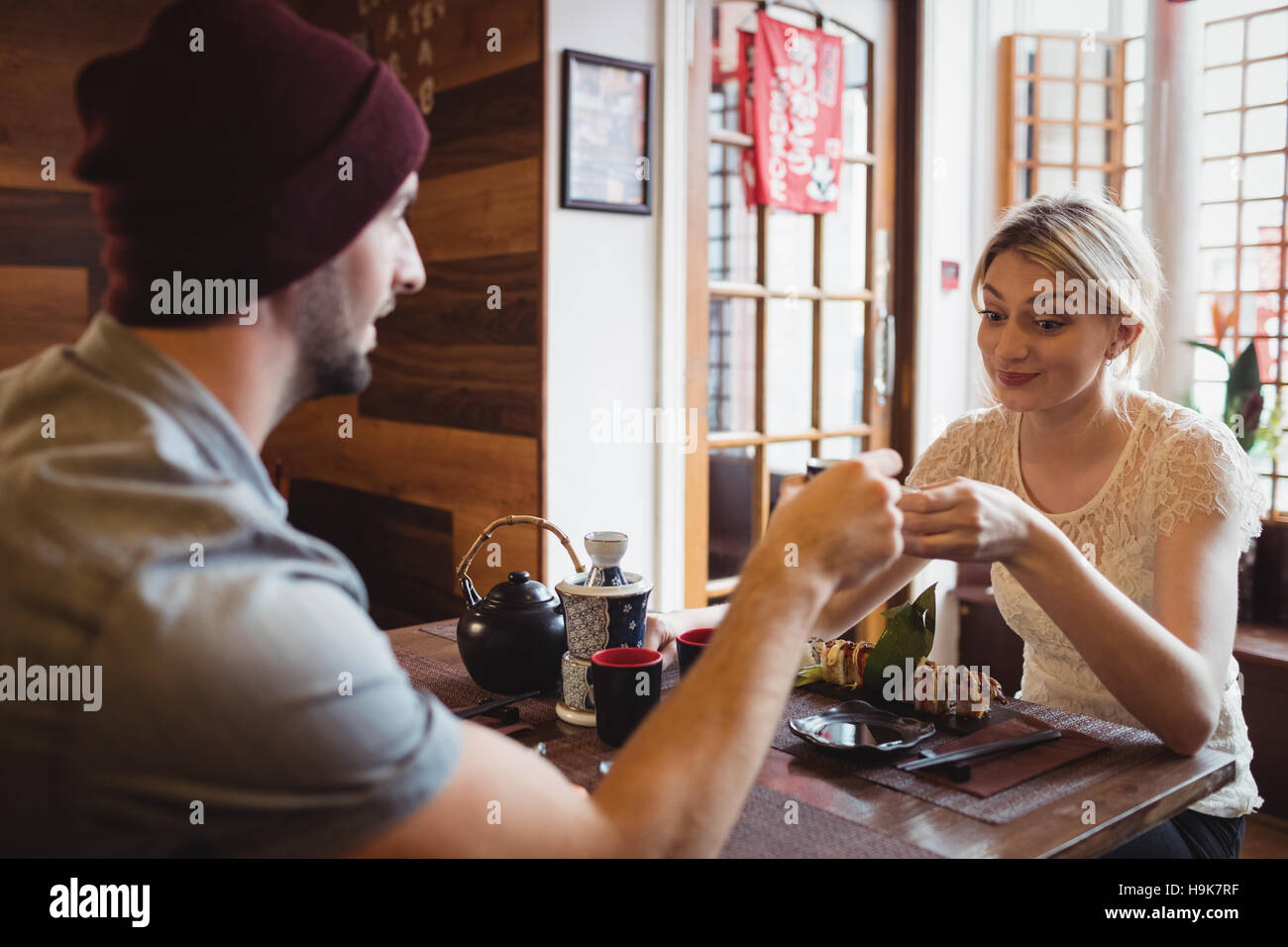 Couple toasting a cup of sake while having sushi Stock Photo - Alamy