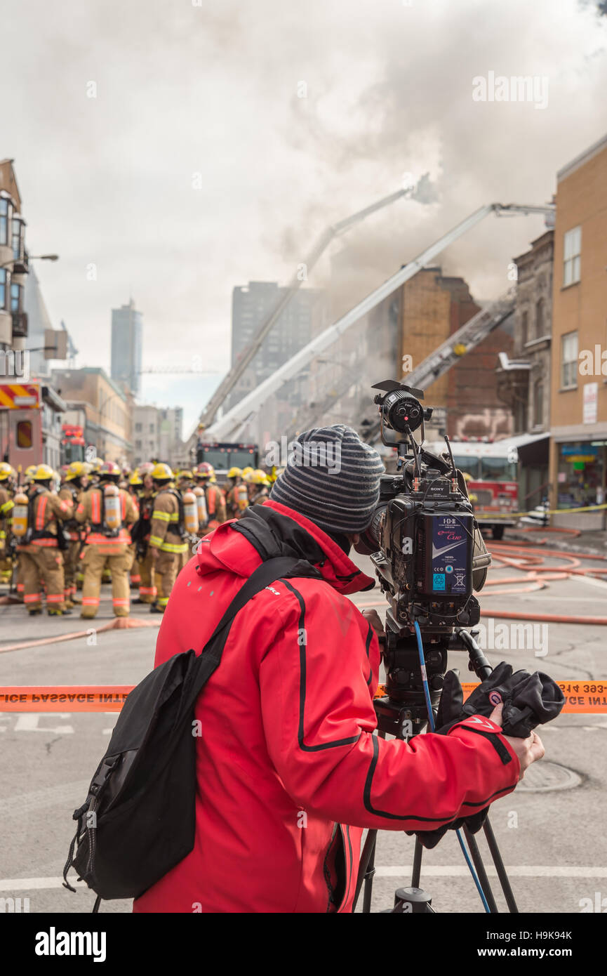 Montreal, CA - 23 Nov 2016: A cameraman is filming firefighters working ...