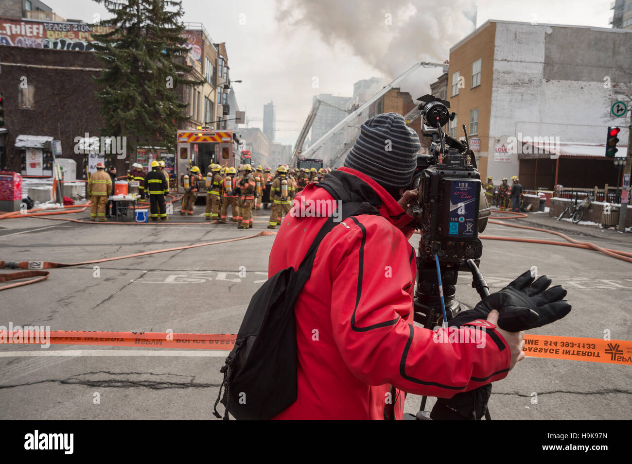 Montreal, CA - 23 Nov 2016: A cameraman is filming firefighters working ...