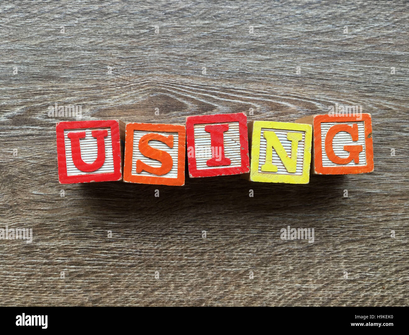Alphabet wood blocks making the word USING Stock Photo - Alamy