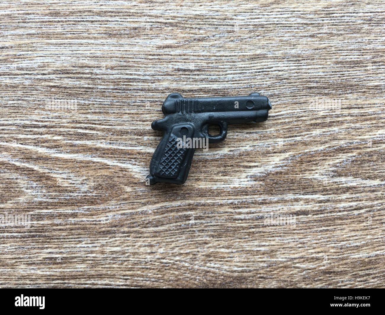 Tiny Toy guns on a wood backgound texture Stock Photo - Alamy