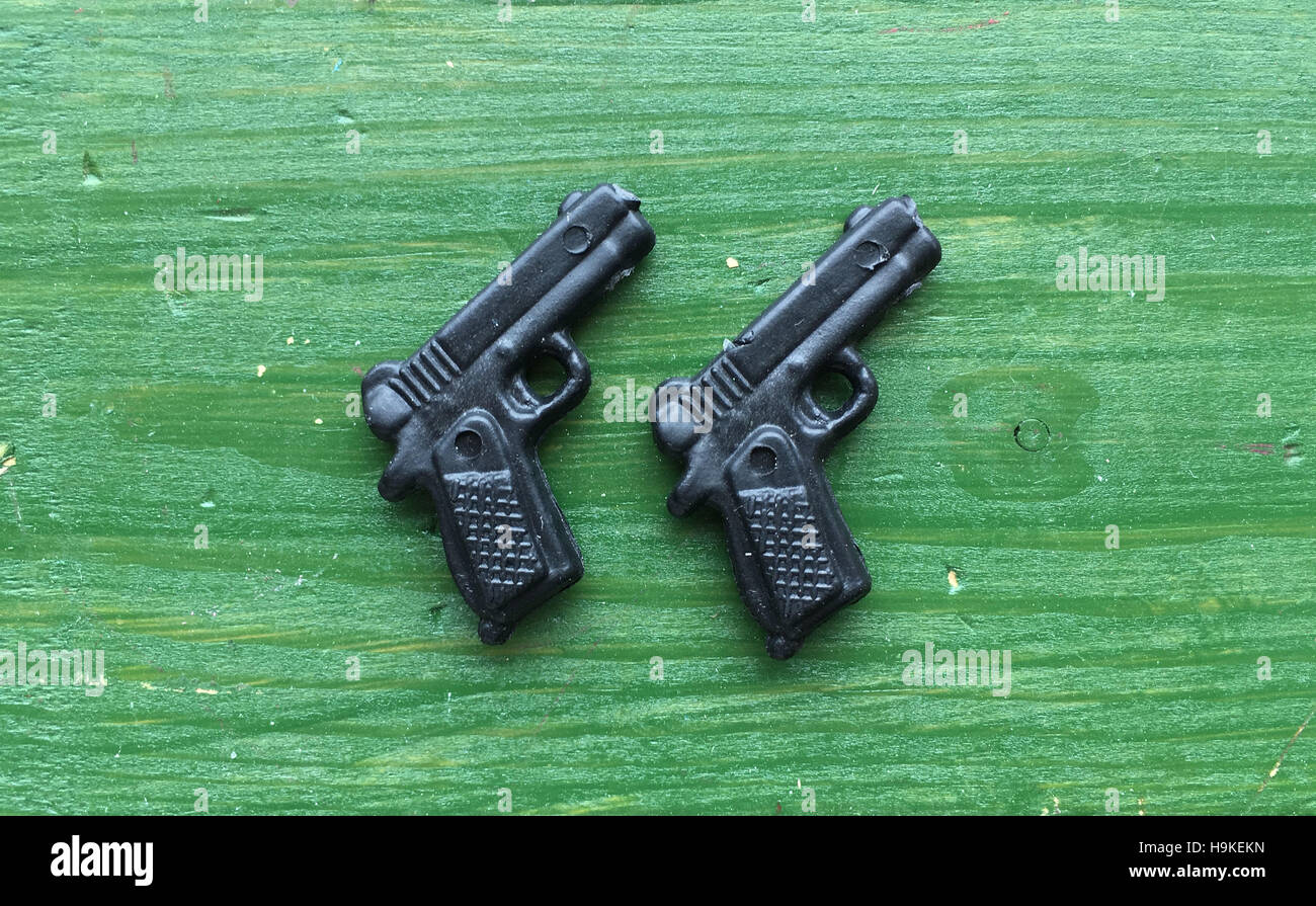 Tiny Toy guns on a wood backgound texture Stock Photo - Alamy