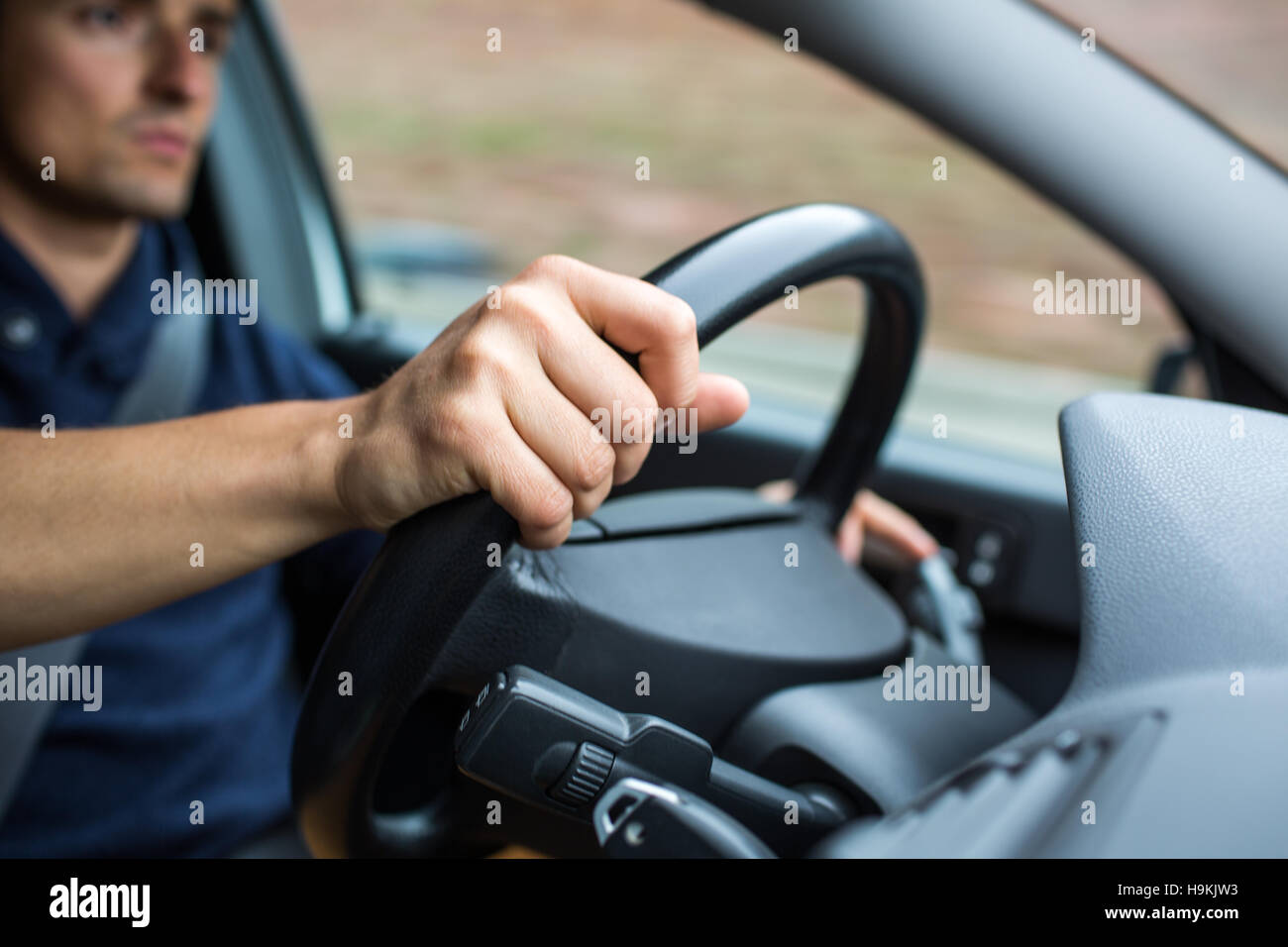 Male driver's hands driving a car on a highway (color toned image ...