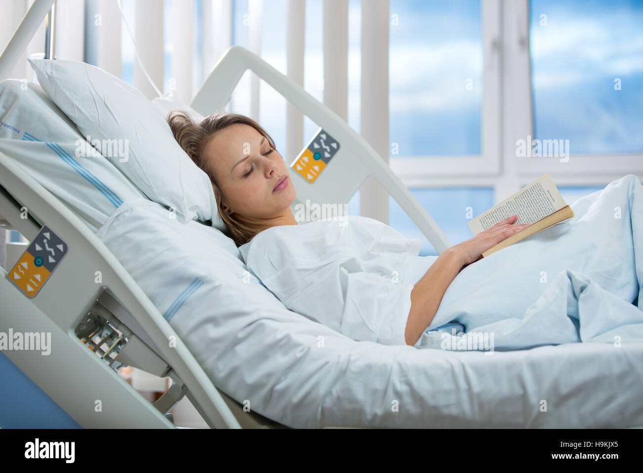 Pretty, young, female patient in a modern hospital room. Getting better ...